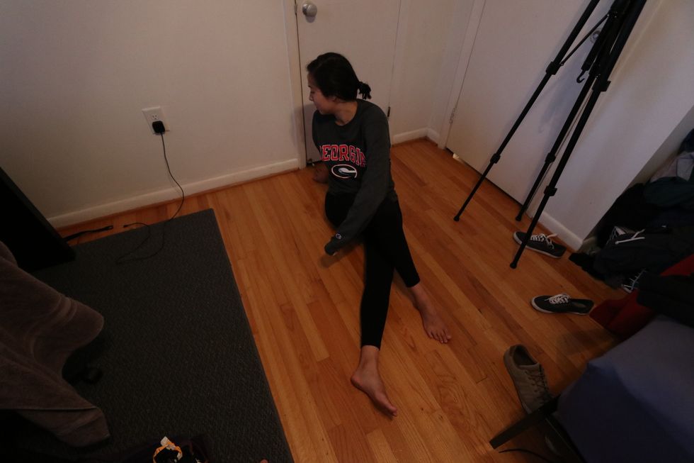 To stretch out your laterals, sit on the floor and cross one foot over ...